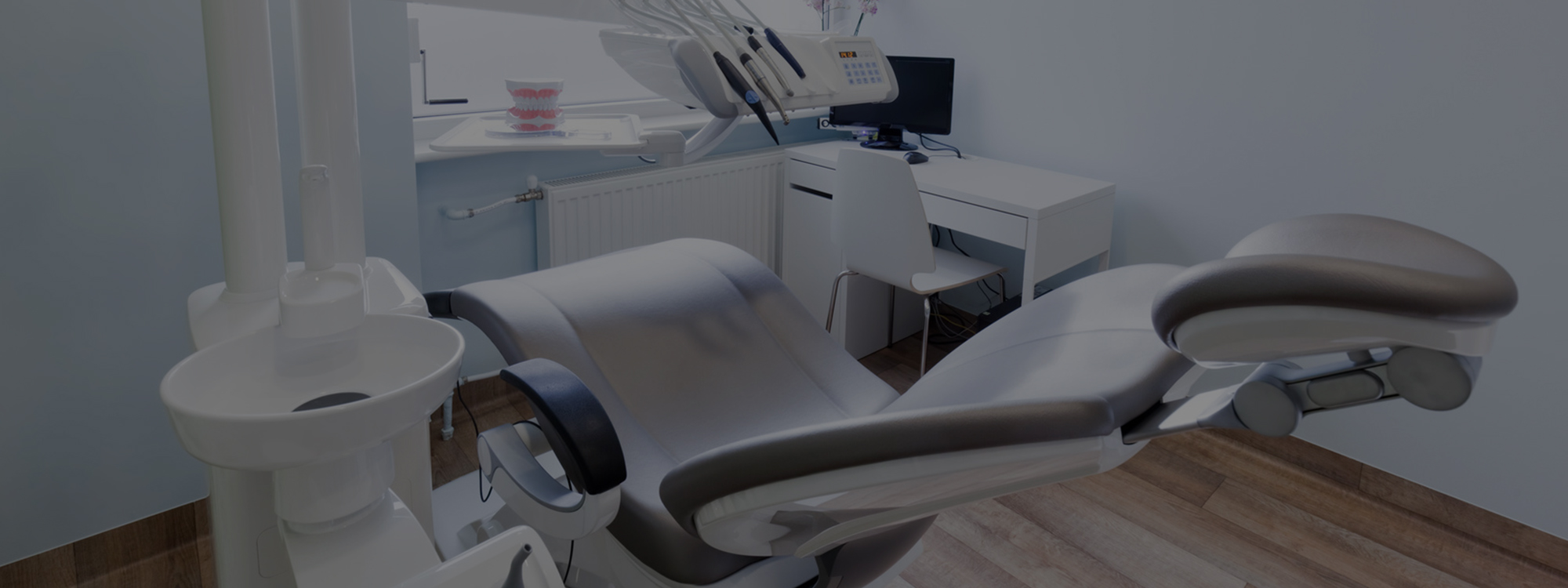 smiling asian woman sitting at the dentist and smiles towards th ...